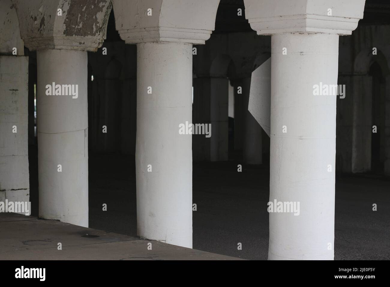 An inner city colonnade of columns holding up a bridge overhead Stock ...