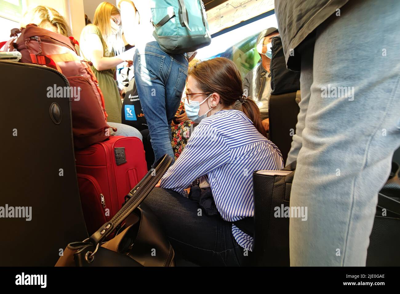 Very many people sitting and standing overcrowded in a local train ...