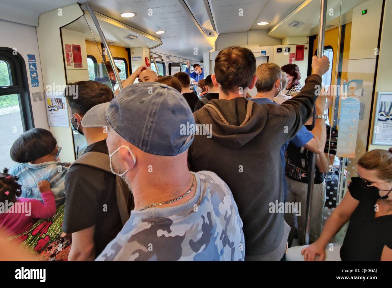 Very many people standing overcrowded in a local train, chaos in local ...
