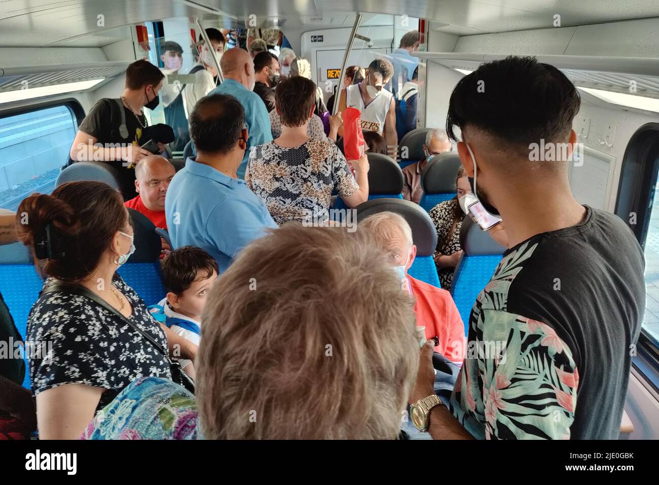 Very many people standing overcrowded in a local train, chaos in local ...