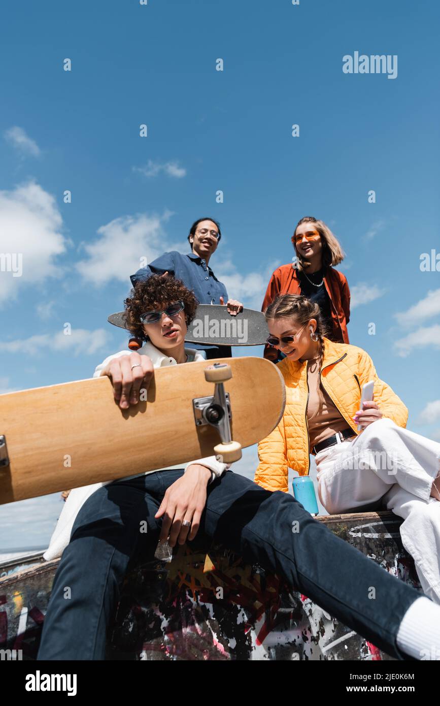 low angle view of young friends with skateboard and longboard against ...