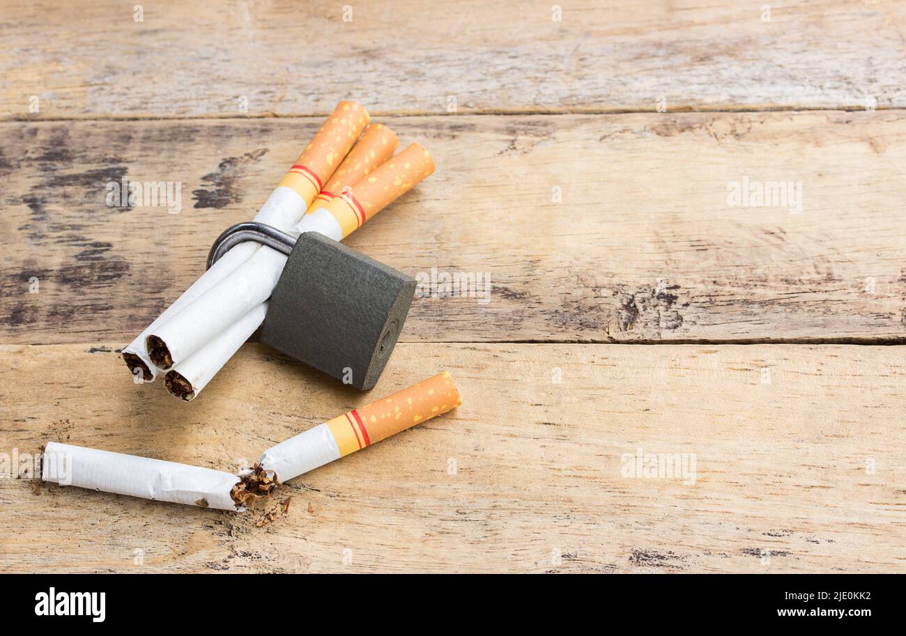 Tobacco cigarettes with lock on a wooden table background. cigarette ...