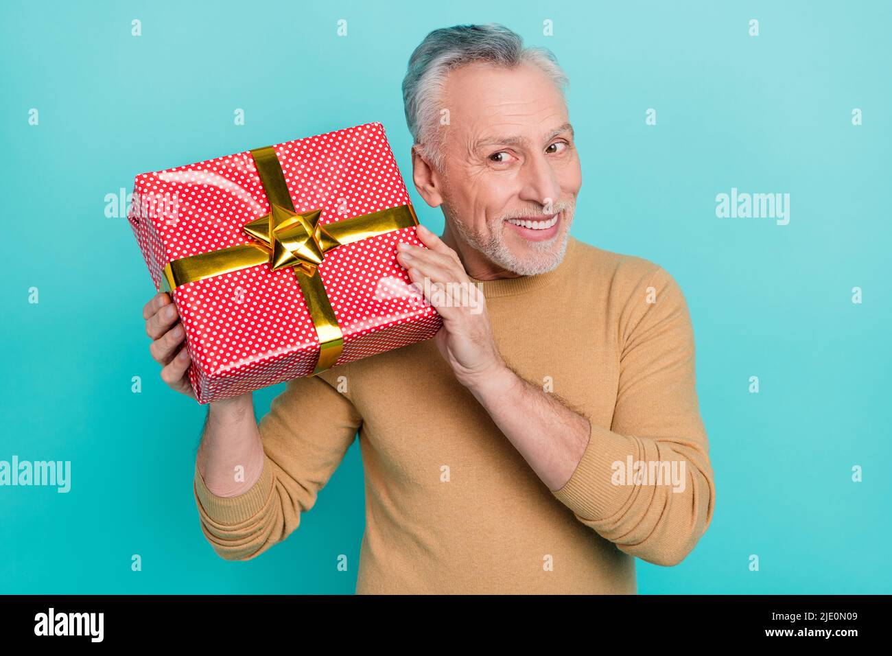 Photo of cheerful mature male shake his birthday present box try to ...