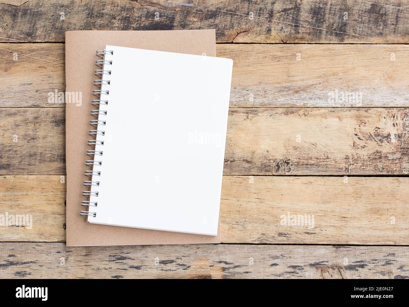 Open blank notepad with empty white pages laying on a wooden table ...