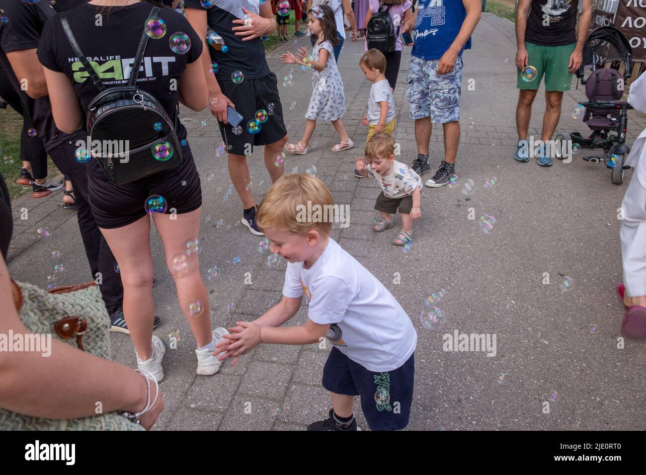 Kids playing with the blowing bubbles during a festival Stock Photo - Alamy