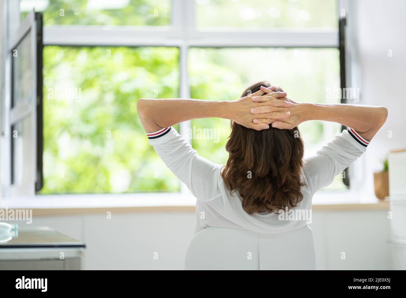 Relaxed Young Businesswoman Relaxing On Chair Behind Desk At Office ...