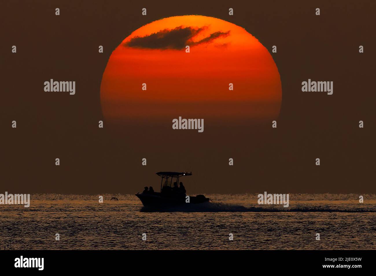 A lone boat passes under the setting sun in the Florida Keys (Marathon ...