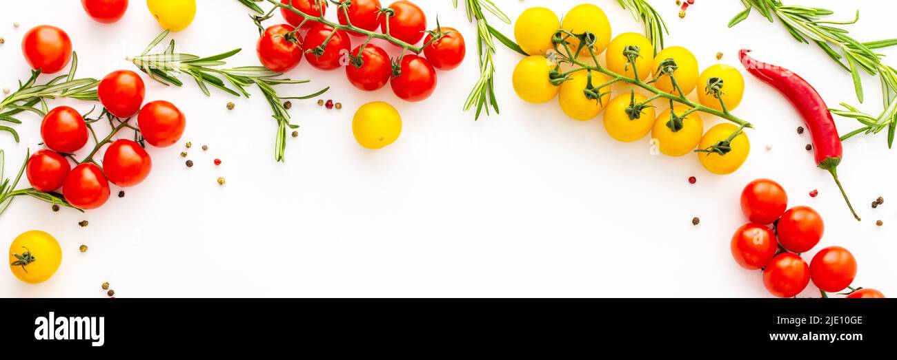 Yellow and red tomatoes, hot peppers, rosemary and spices on a white ...