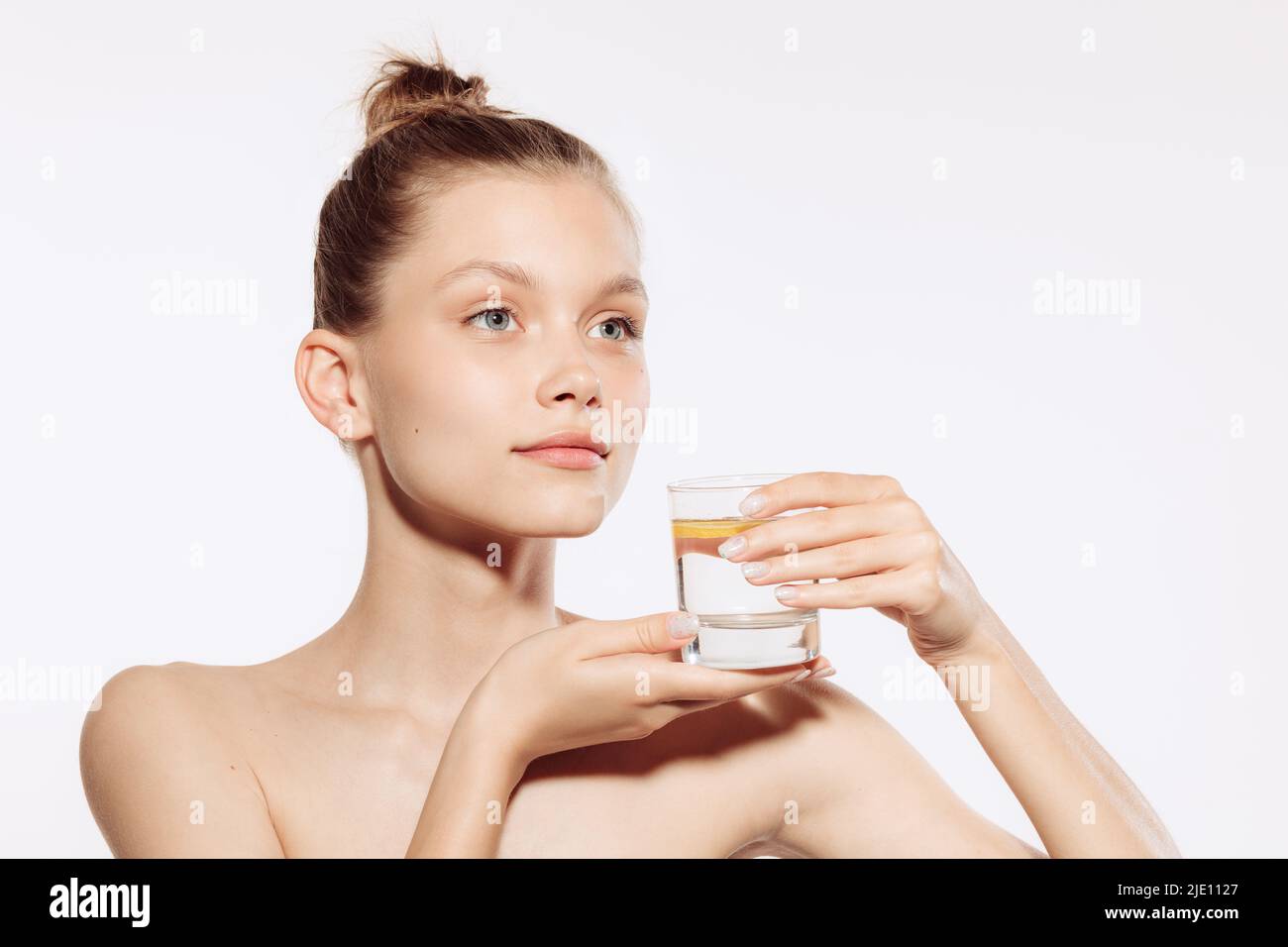 Portrait of young female fashion model without makeup isolated on white ...