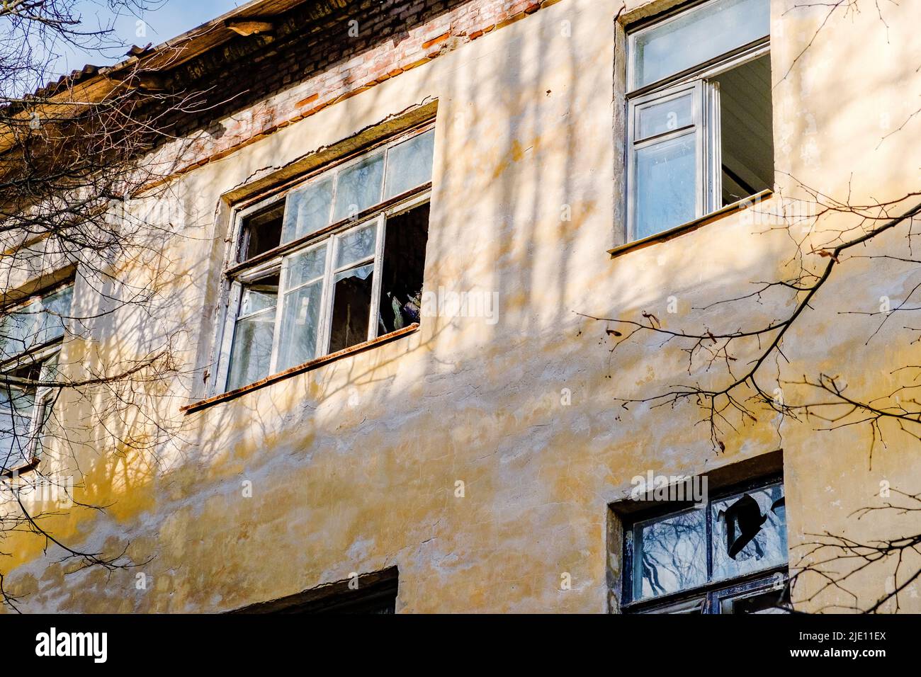 Abandoned building with broken windows. A fragment of the facade ...