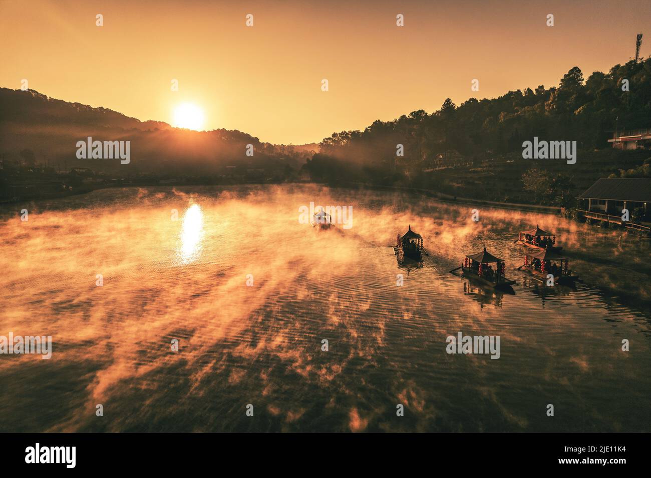 Aerial shot of Chinese rowboat at sunrise with fog over the Ban Rak ...