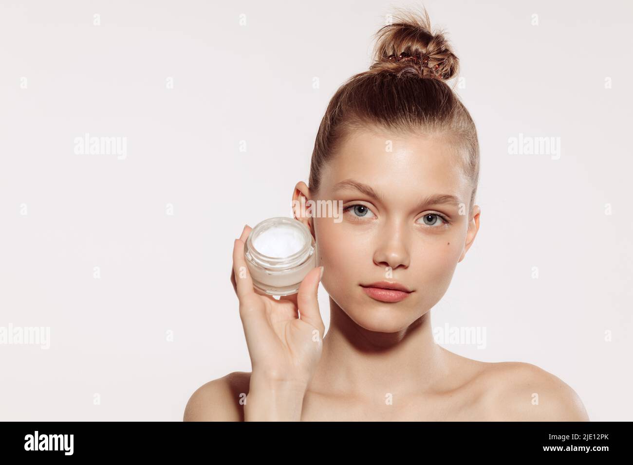 Half-length portrait of charming young girl without makeup holding ...