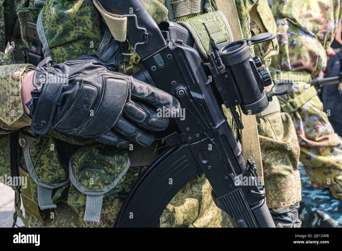 An armed soldier or airsoft player holds a combat or sporting rifle ...