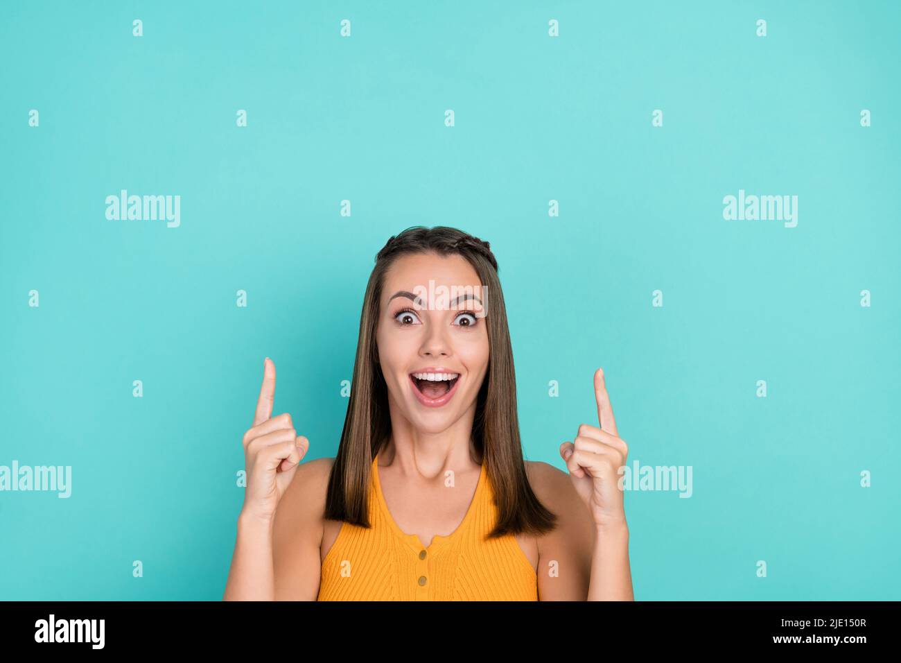 Photo of surprised cheerful happy young woman point finger up empty ...