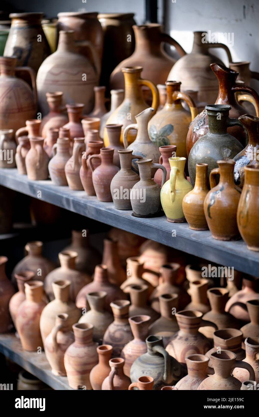 Many unique handmade colorful clay jugs and vases of various shapes on ...