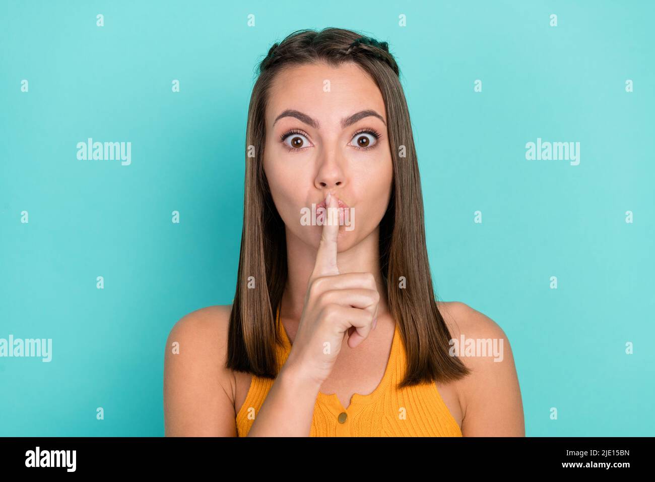 Photo of silent scared young woman hold finger lips secret tell rumor ...