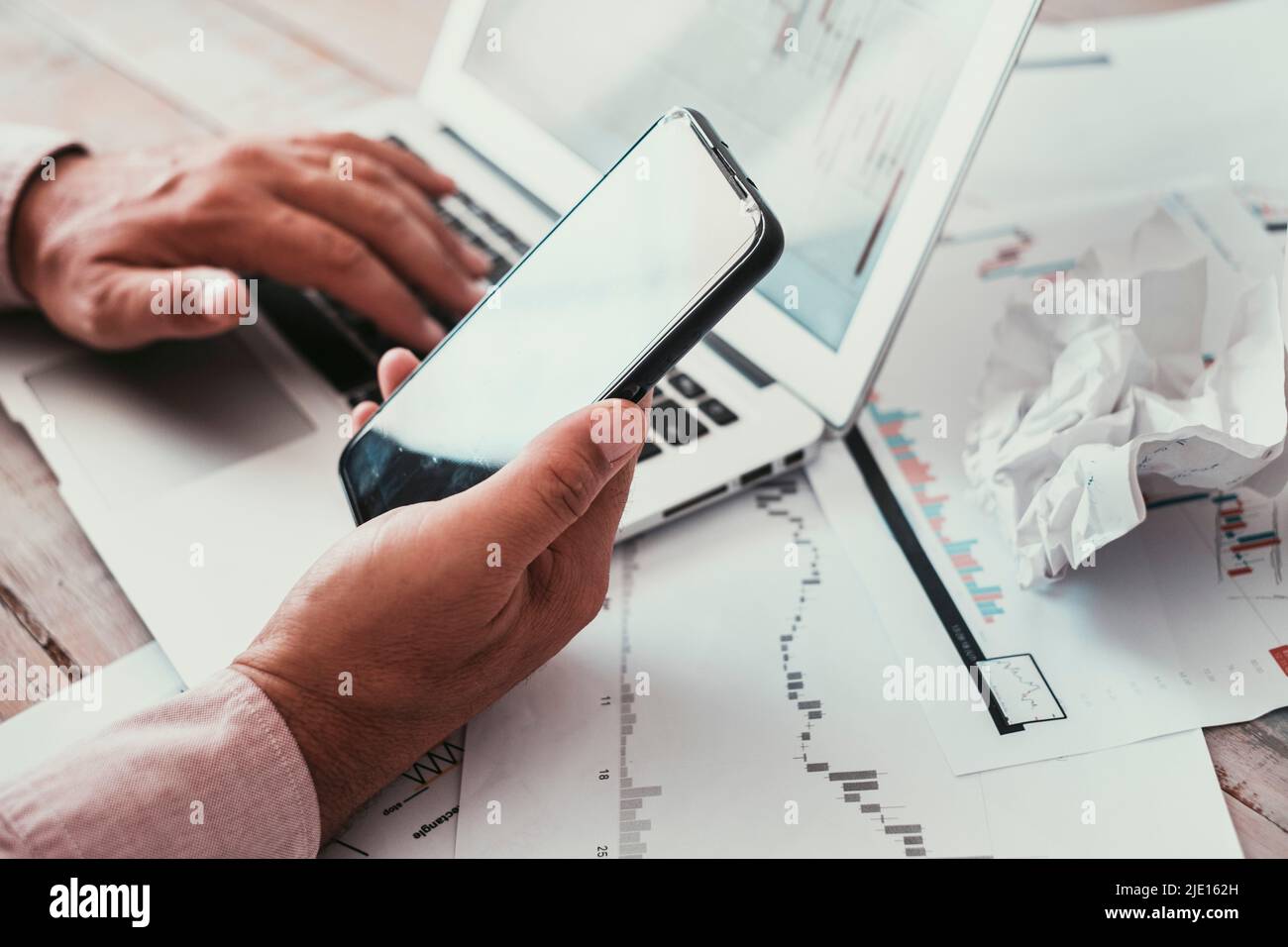 Close up of man hands with mobile phone and laptop computer. People ...