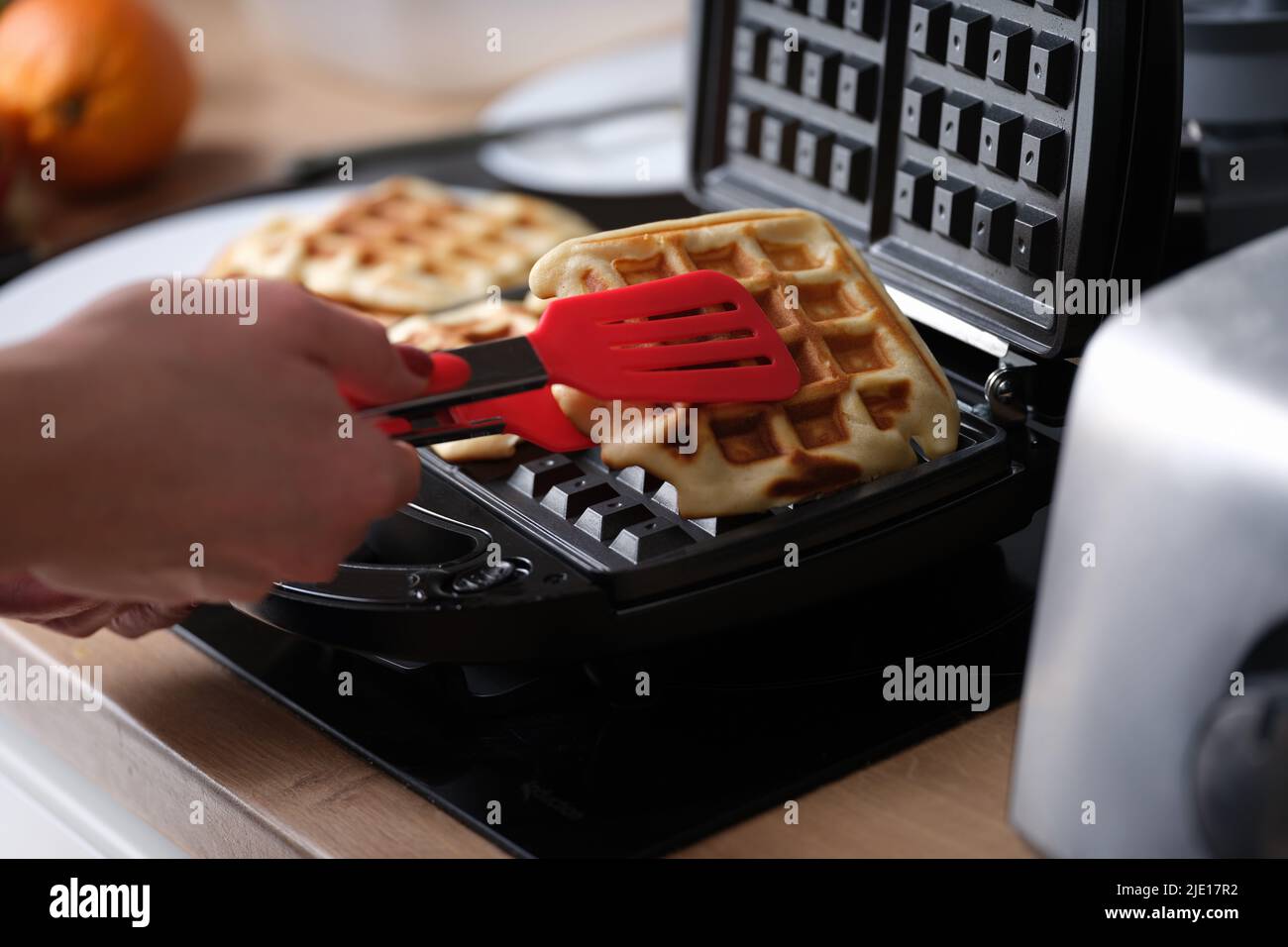 Person prepares waffles on waffle iron at home Stock Photo - Alamy