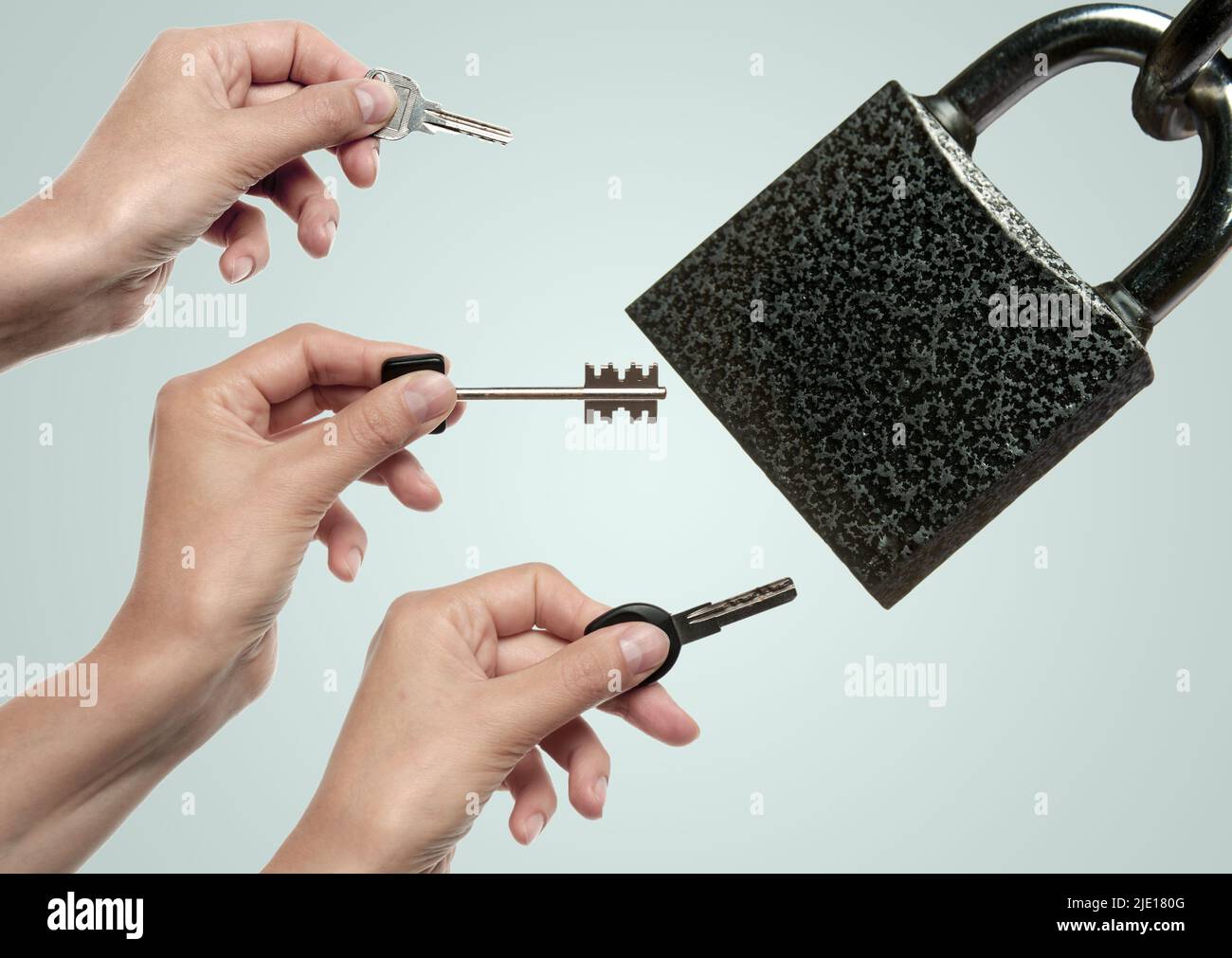 Three woman hands with different keys try to open the lock. Concept of ...