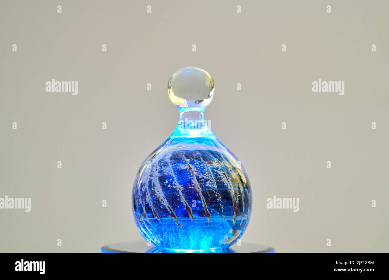 Colored glass paper weight on a plain background Stock Photo - Alamy