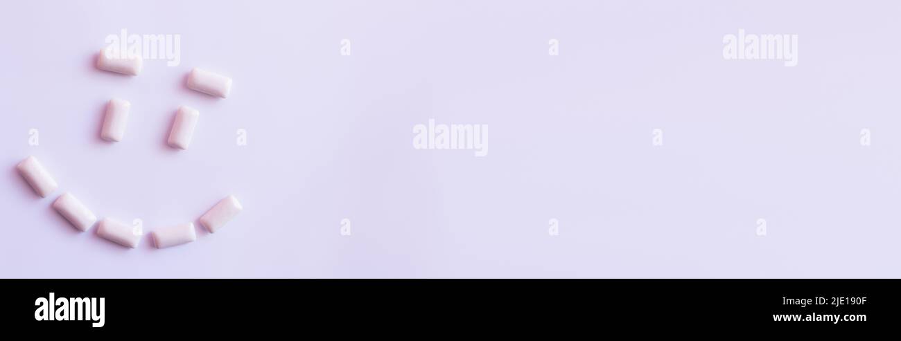 Flat lay of smile symbol from chewing gums on white background, banner ...