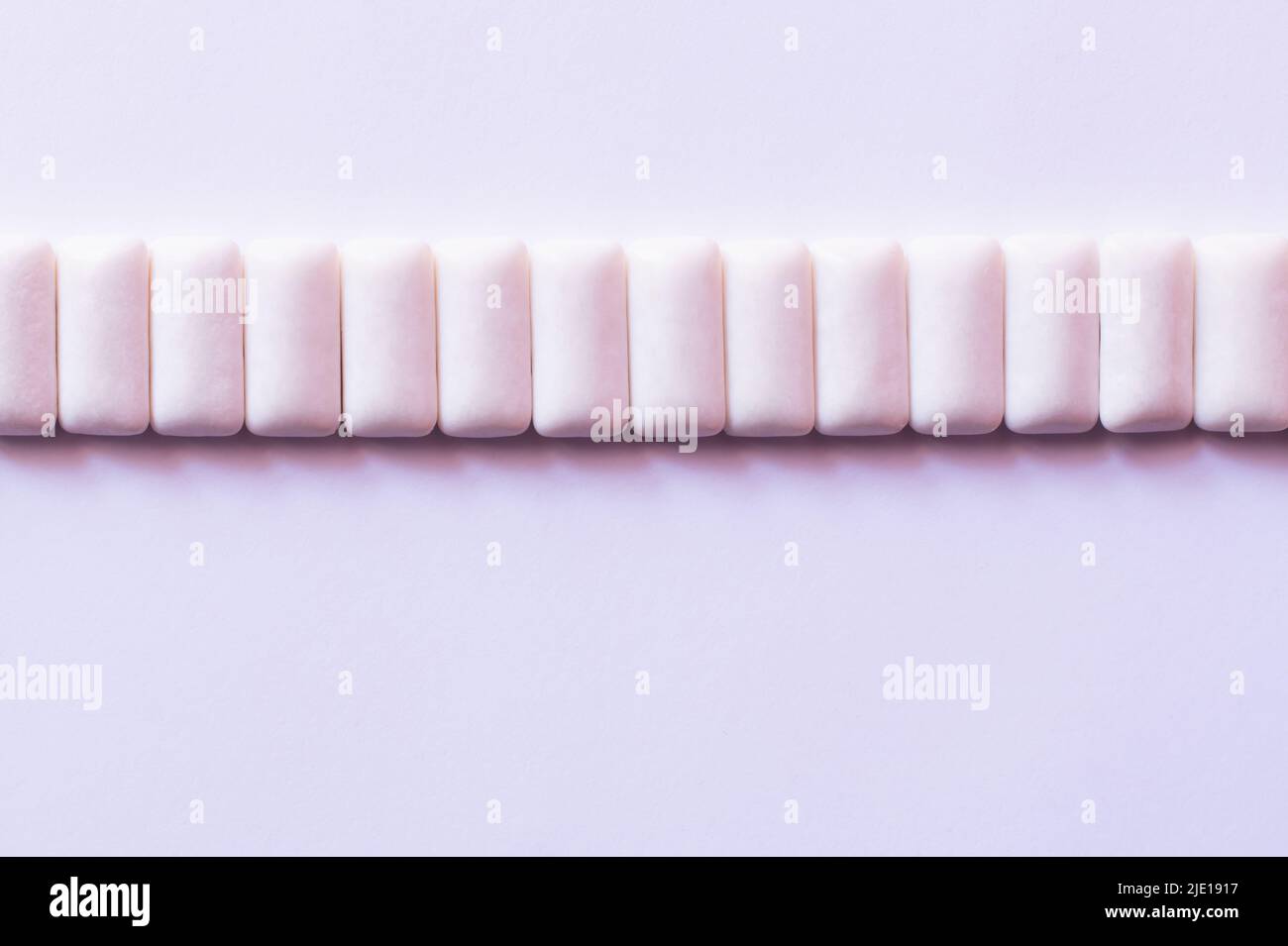 Flat lay with row from chewing gums on white background Stock Photo - Alamy