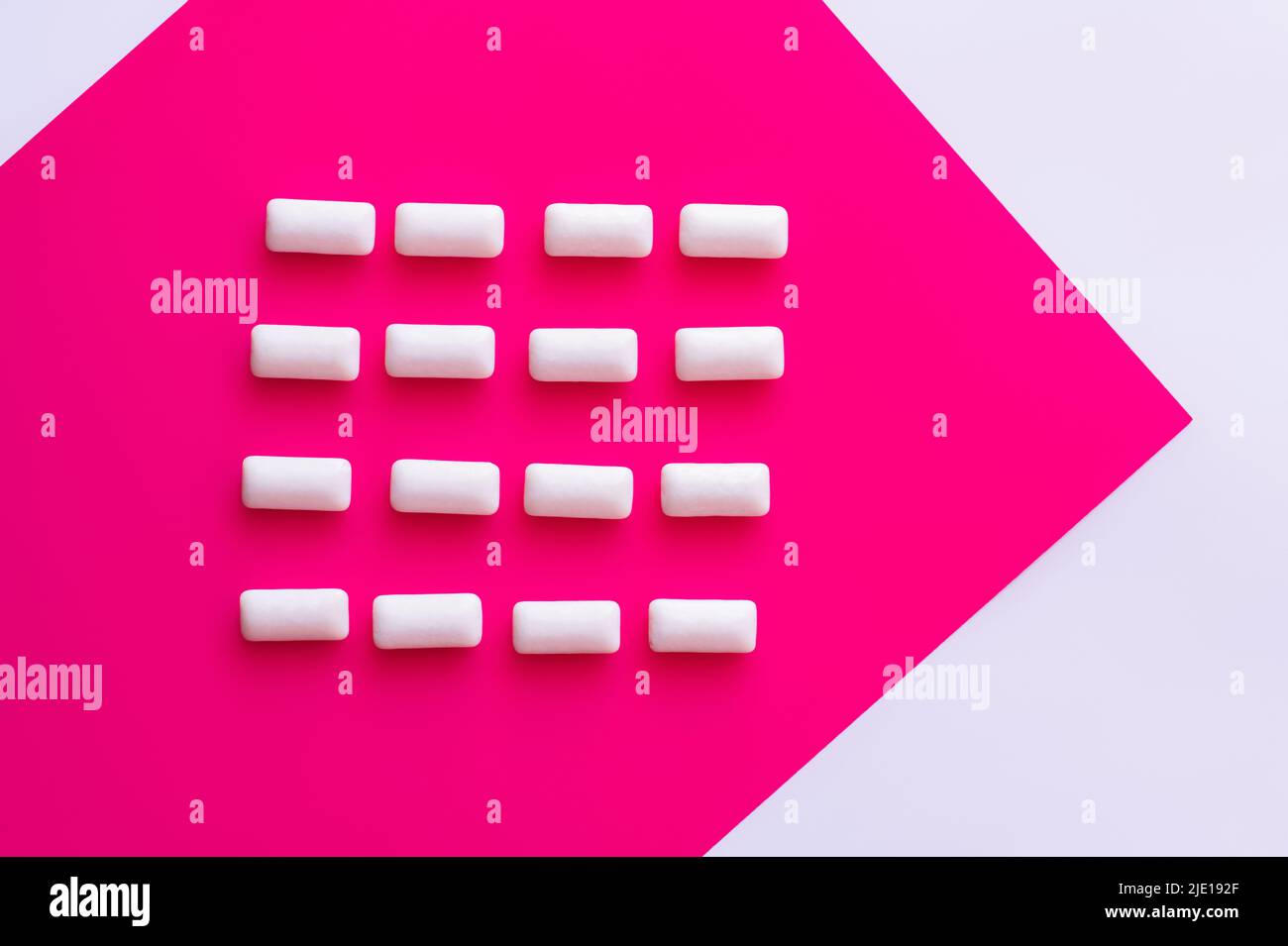 Flat lay with chewing gums on pink and white background Stock Photo - Alamy