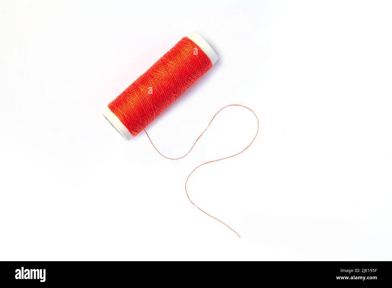 Spool of red color thread isolated on white background Stock Photo - Alamy