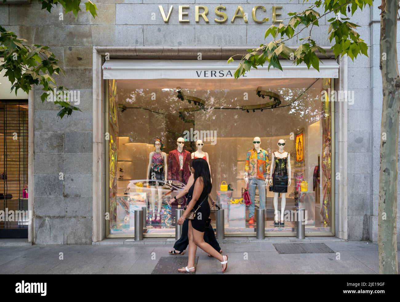 Pedestrians walk past the Italian luxury fashion company Versace store ...
