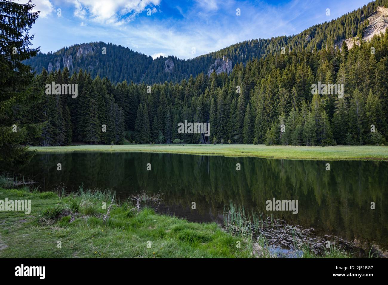 A small blue reflecting lake and clear mountain cool water with stone ...