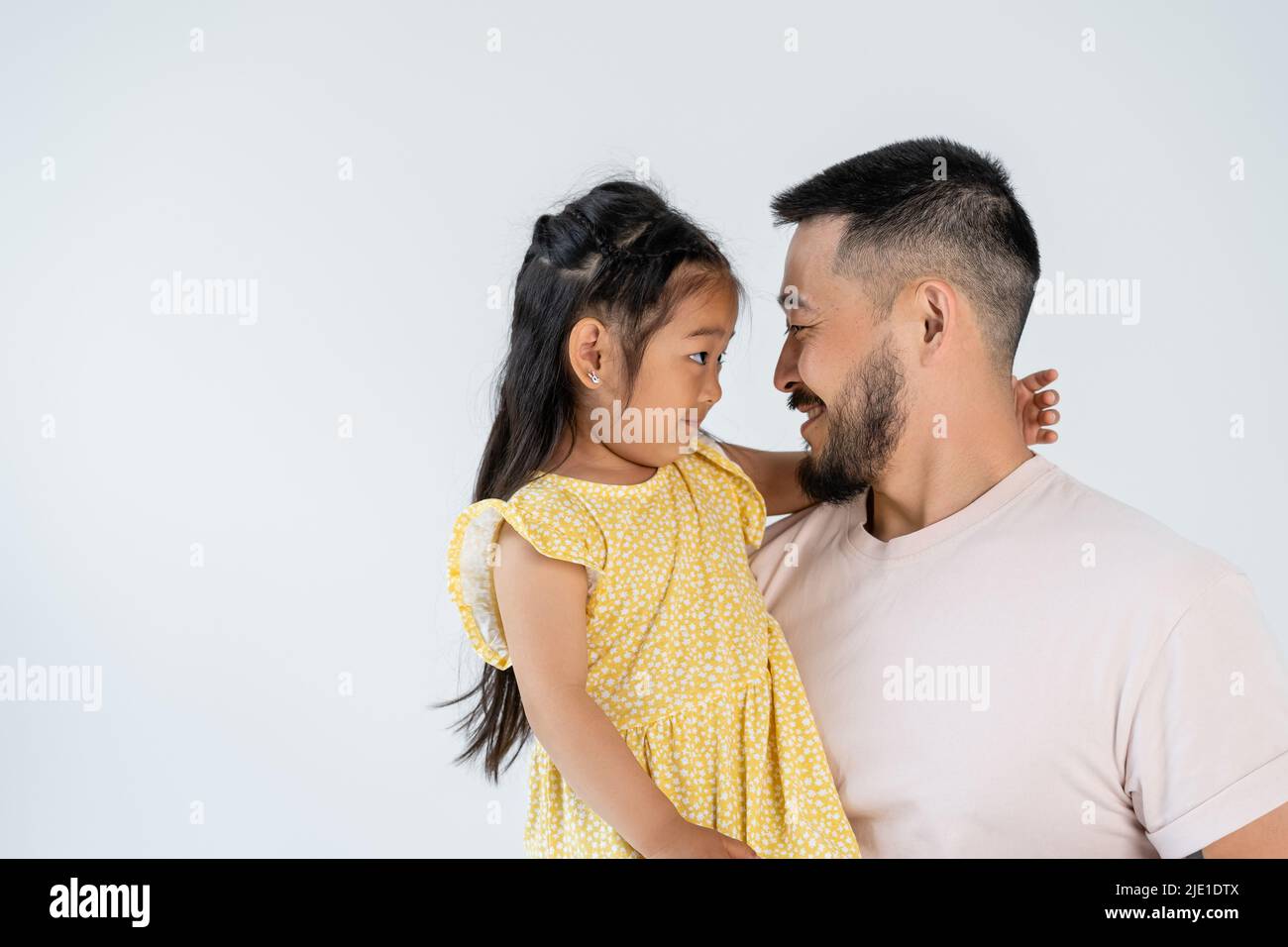 side view of happy father and daughter looking at each other isolated ...