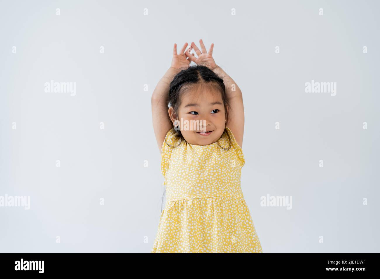 portrait of pleased preschooler and asian girl standing with hands ...