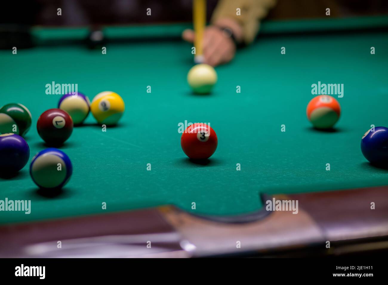 the ball with number 3 at which the cue ball is aiming. a man plays ...