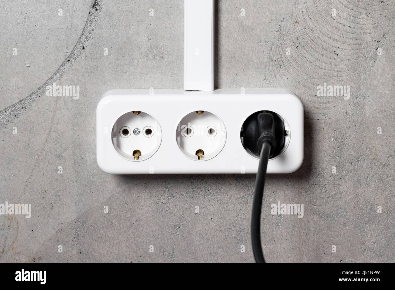 Group of white european electrical outlets with plug on gray concrete ...