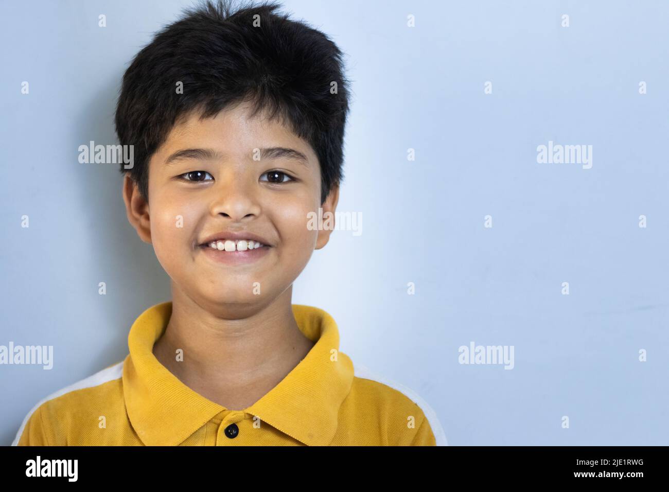portrait of happy Indian kid looking on camera isolated over blue ...