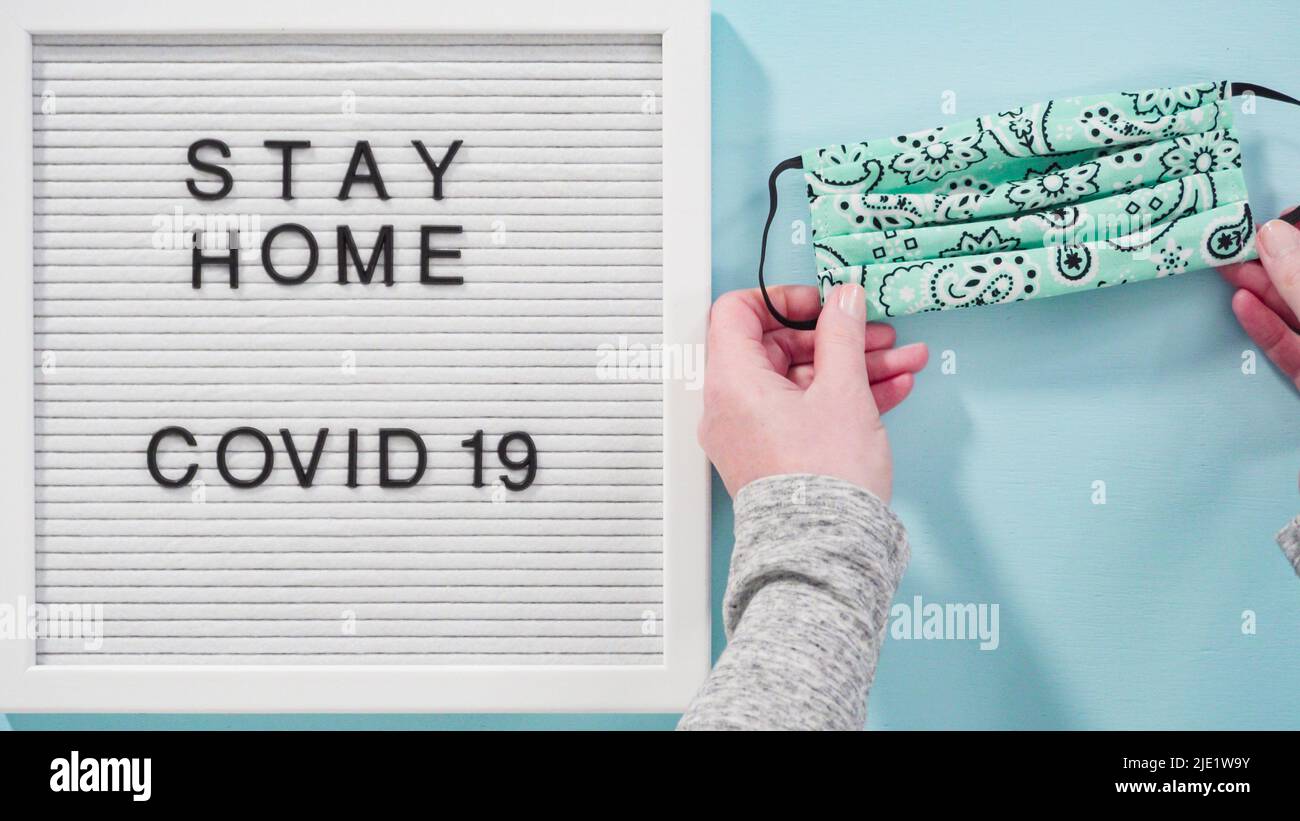 Flat lay. STAY HOME and COVID-19 sign on message board with a homemade ...