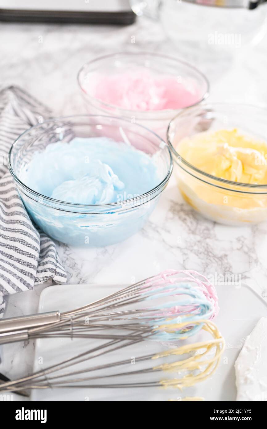 Mixing food coloring into the meringue to bake unicorn meringue cookies ...