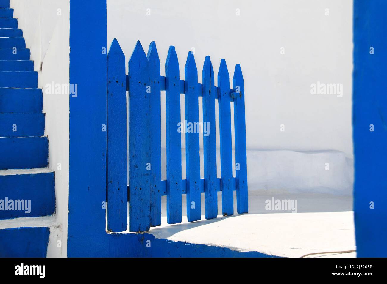 A wooden blue picket fence similar to the colors of Santorini, in the ...