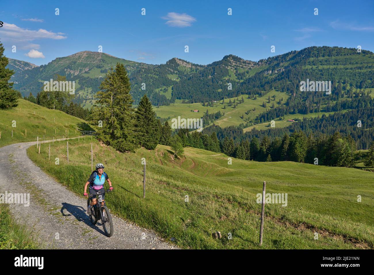 pretty senior woman riding her electric mountain bike on the mountains ...