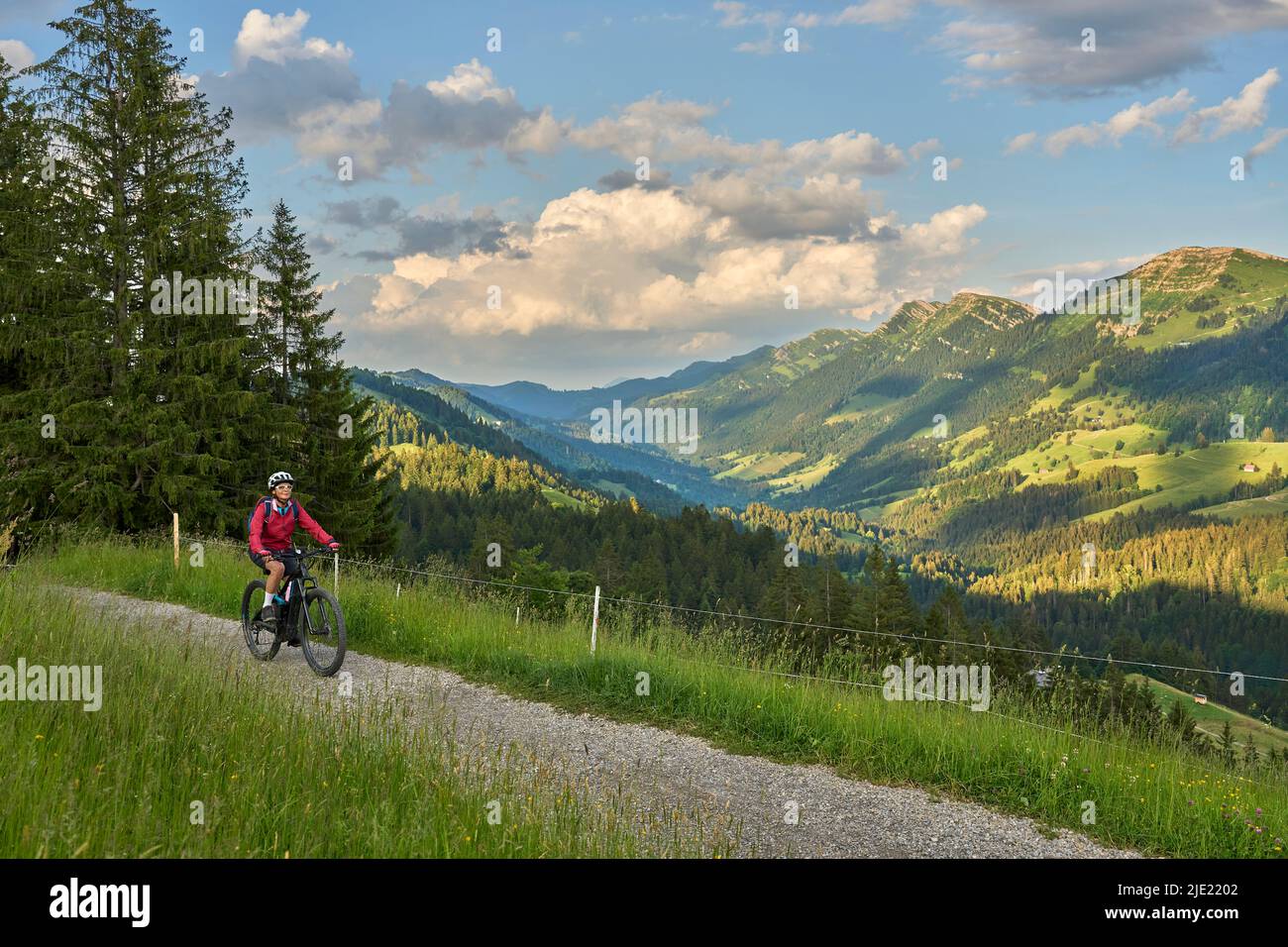 pretty senior woman riding her electric mountain bike on the mountains ...
