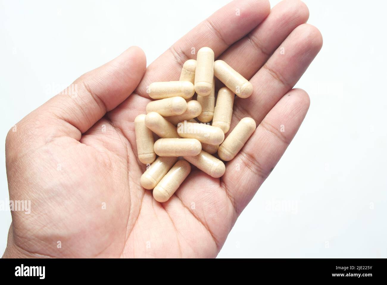 top view of herbal medicine capsule dropping on white Stock Photo - Alamy