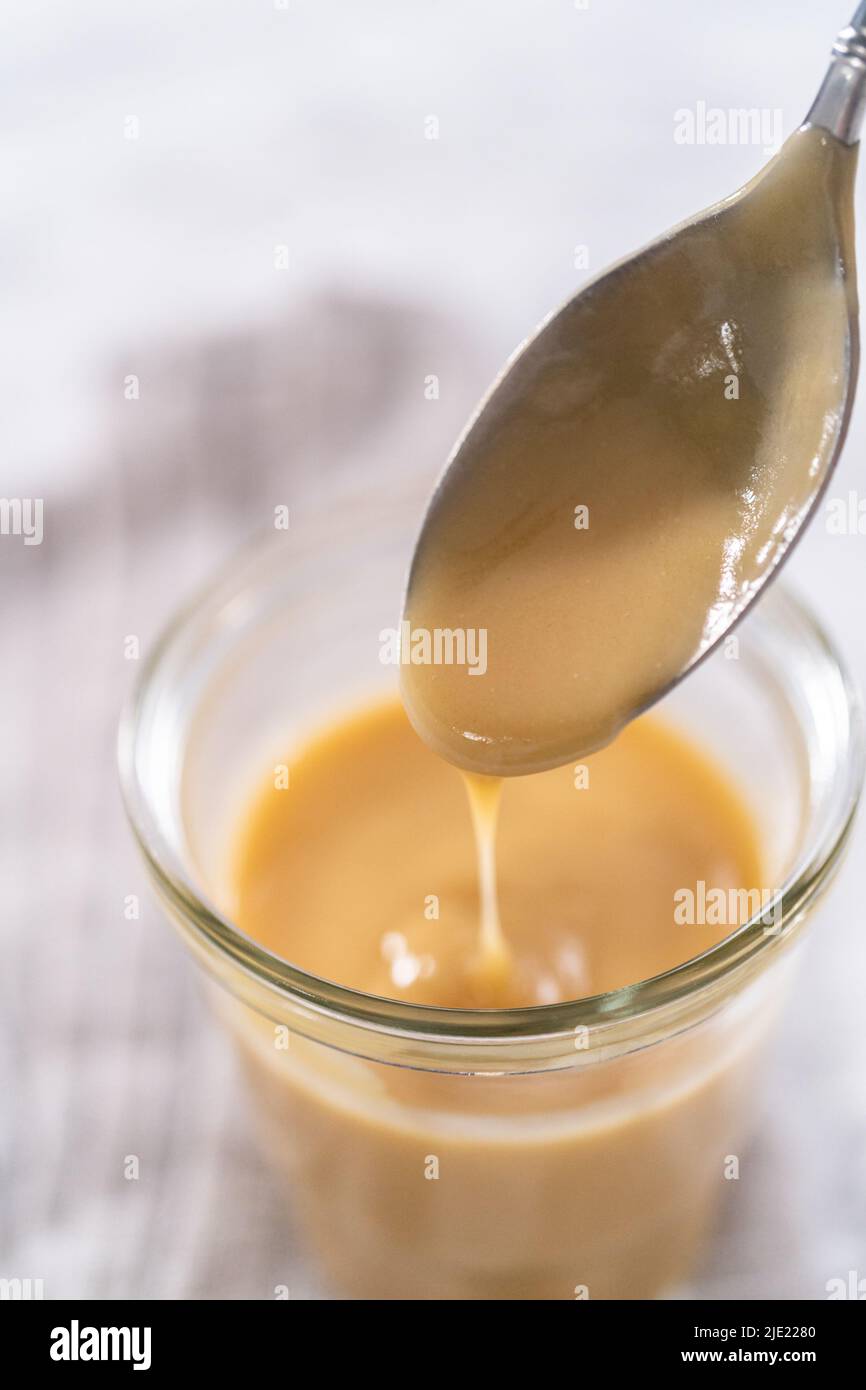 Homemade toffee glaze in a glass jar on the kitchen counter Stock Photo ...