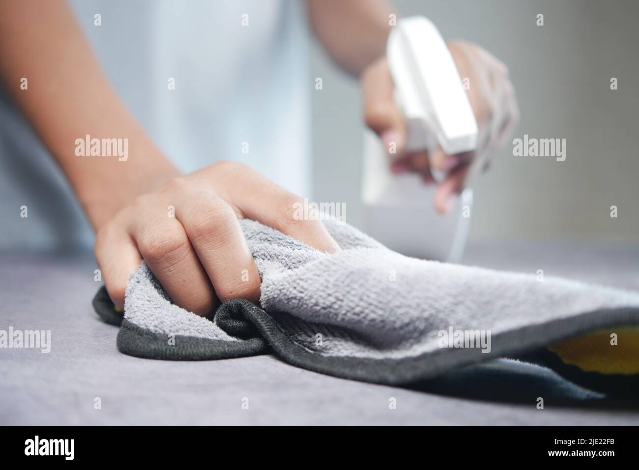 using disinfectant spray to clean table surface Stock Photo - Alamy