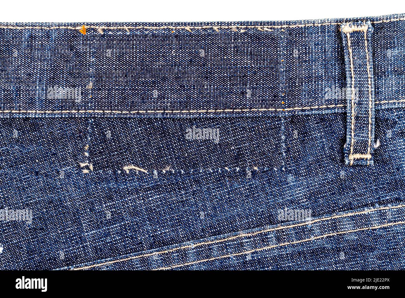 Piece of blue jeans fabric with a ripped of back label isolated on ...