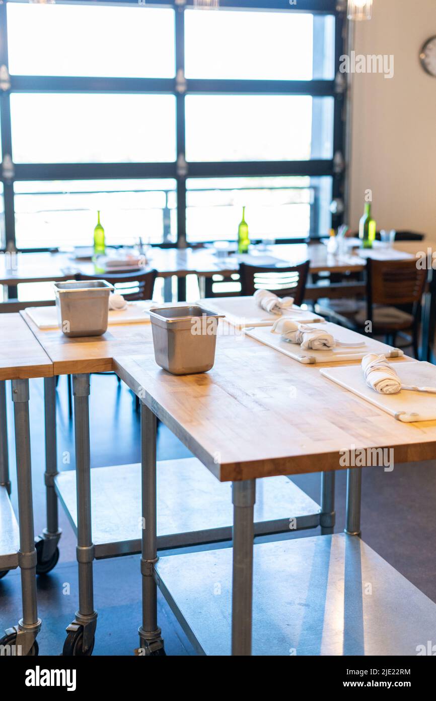 Tables prepared with white cutting boards and aprons for cooking class ...
