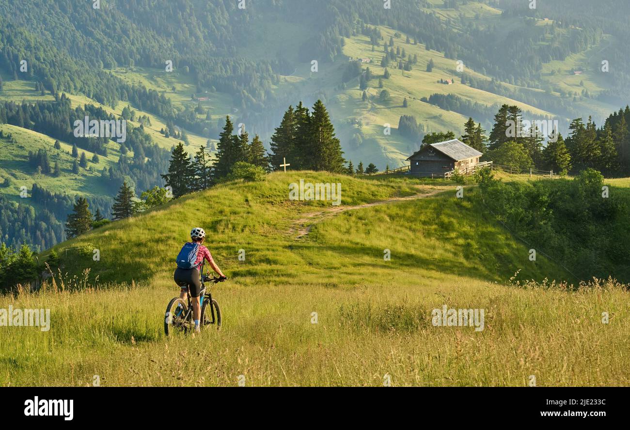 pretty senior woman riding her electric mountain bike on the mountains ...