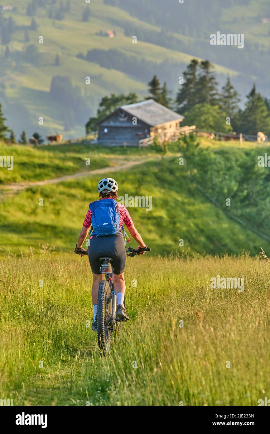 pretty senior woman riding her electric mountain bike on the mountains ...