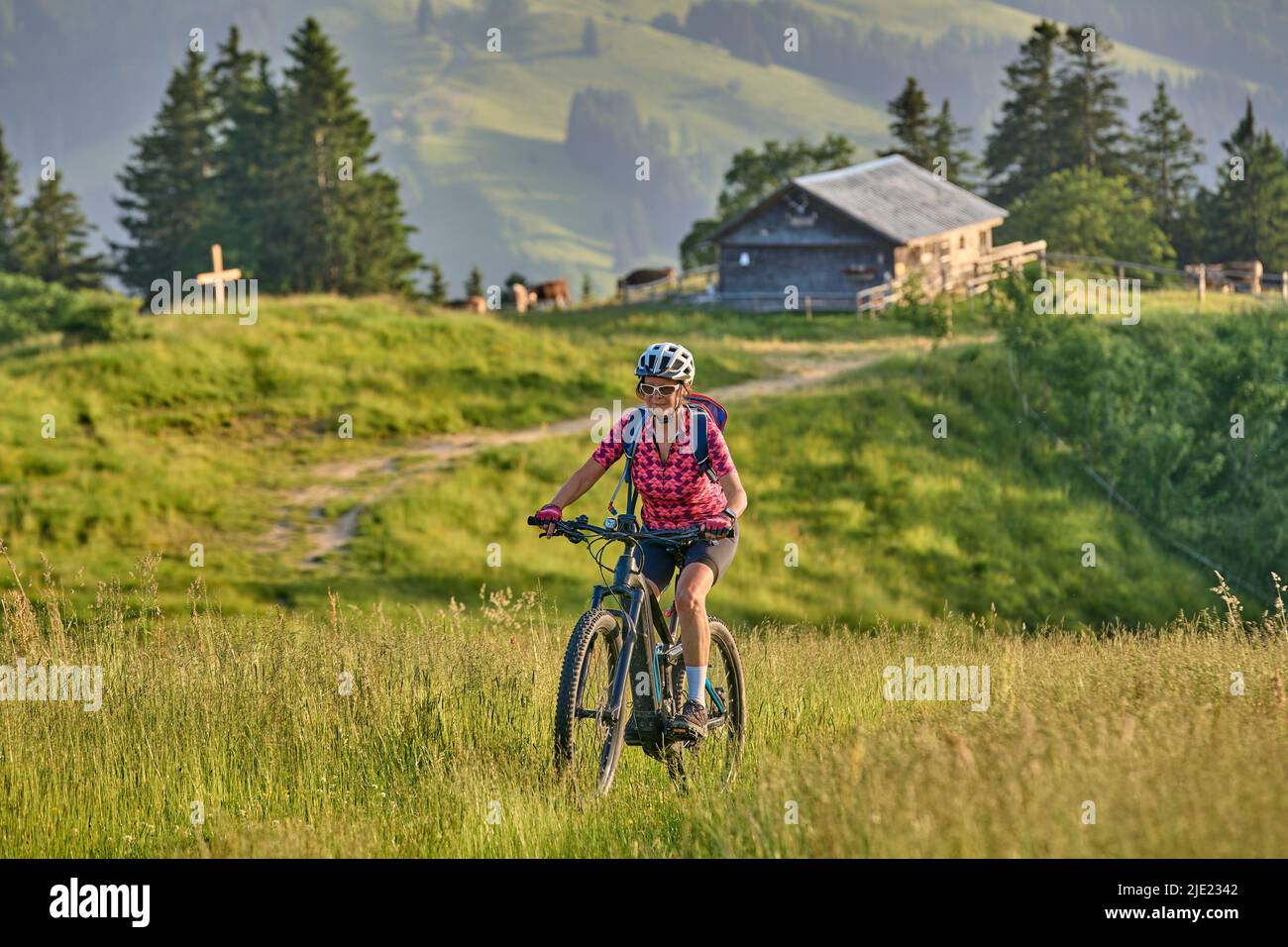 pretty senior woman riding her electric mountain bike on the mountains ...