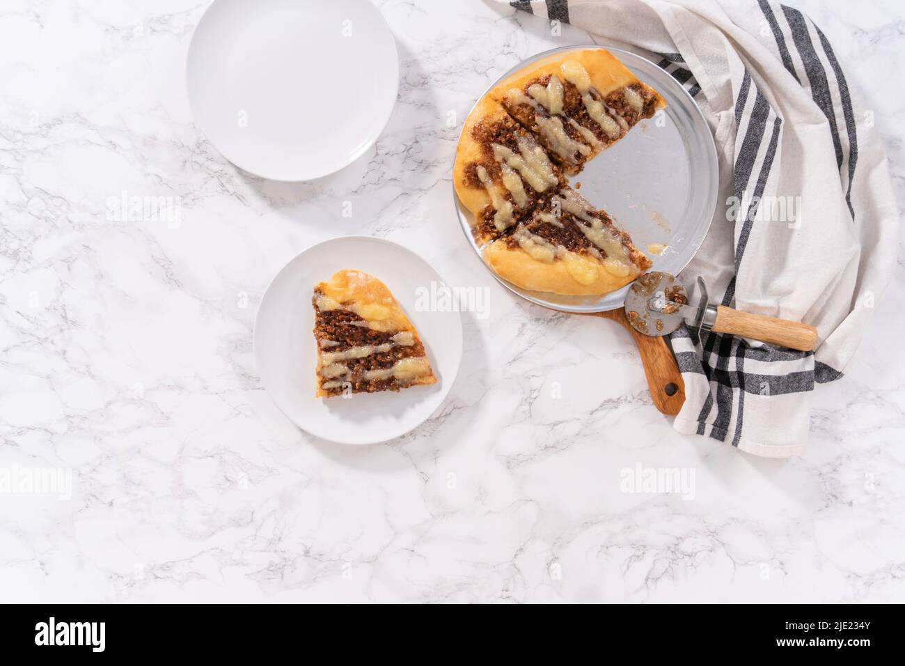 Flat lay. Freshly baked cinnamon dessert pizza with cream cheese ...