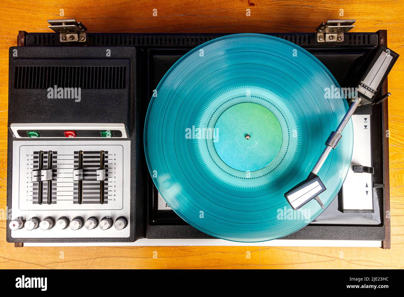 Vintage turntable vinyl record player with turquoise vinyl on a table ...